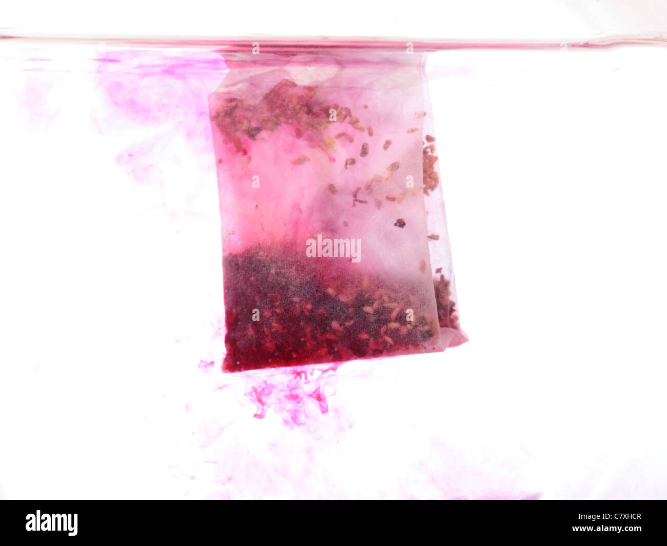 red Teabag in hot water in white background Stock Photo - Alamy