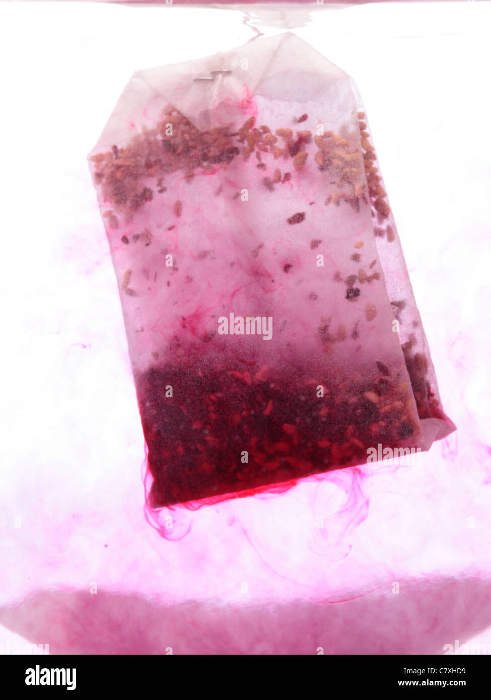 red Teabag in hot water in white background Stock Photo - Alamy