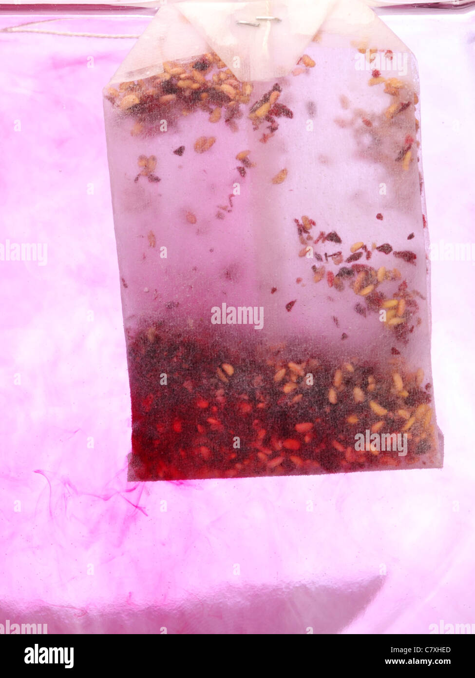 red Teabag in hot water in white background Stock Photo - Alamy