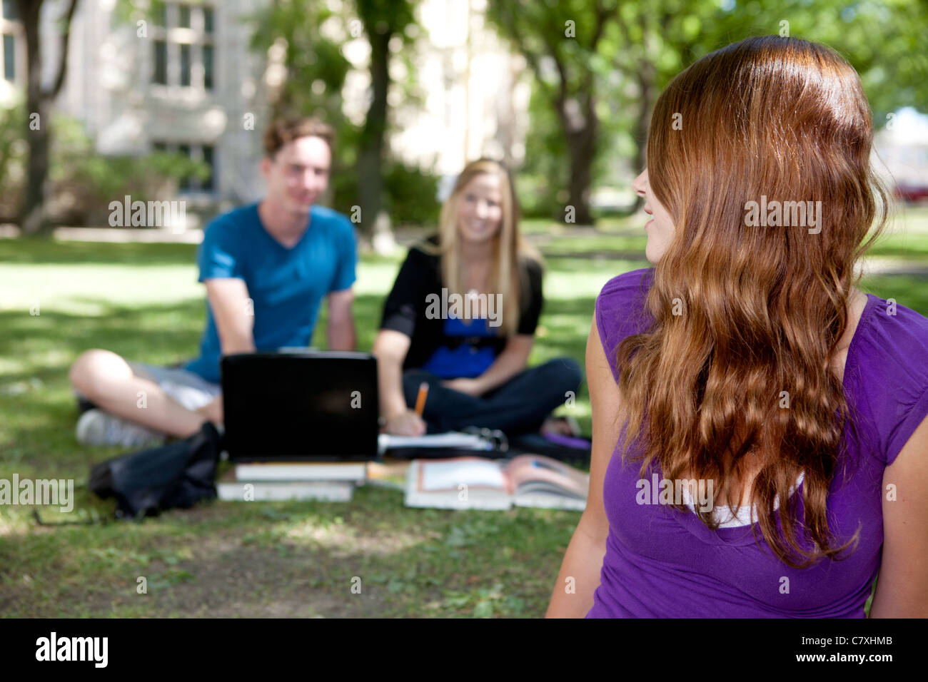 Smiling brunette student looking back at friends Stock Photo - Alamy