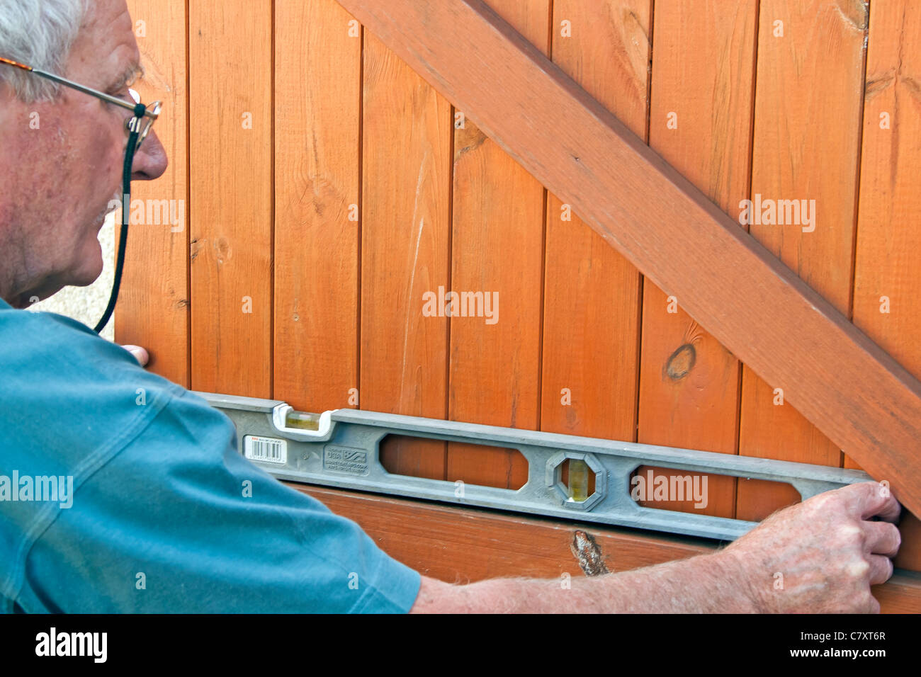 Carpenter checking door is straight with a spirit level Stock Photo - Alamy