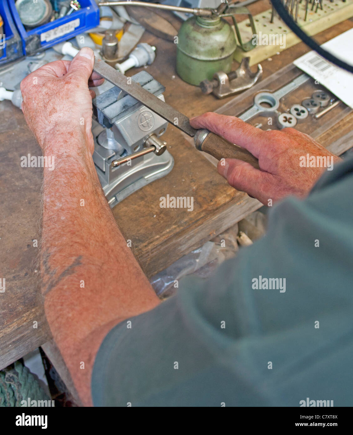 Engineer filing a washer held in a mini vice Stock Photo - Alamy