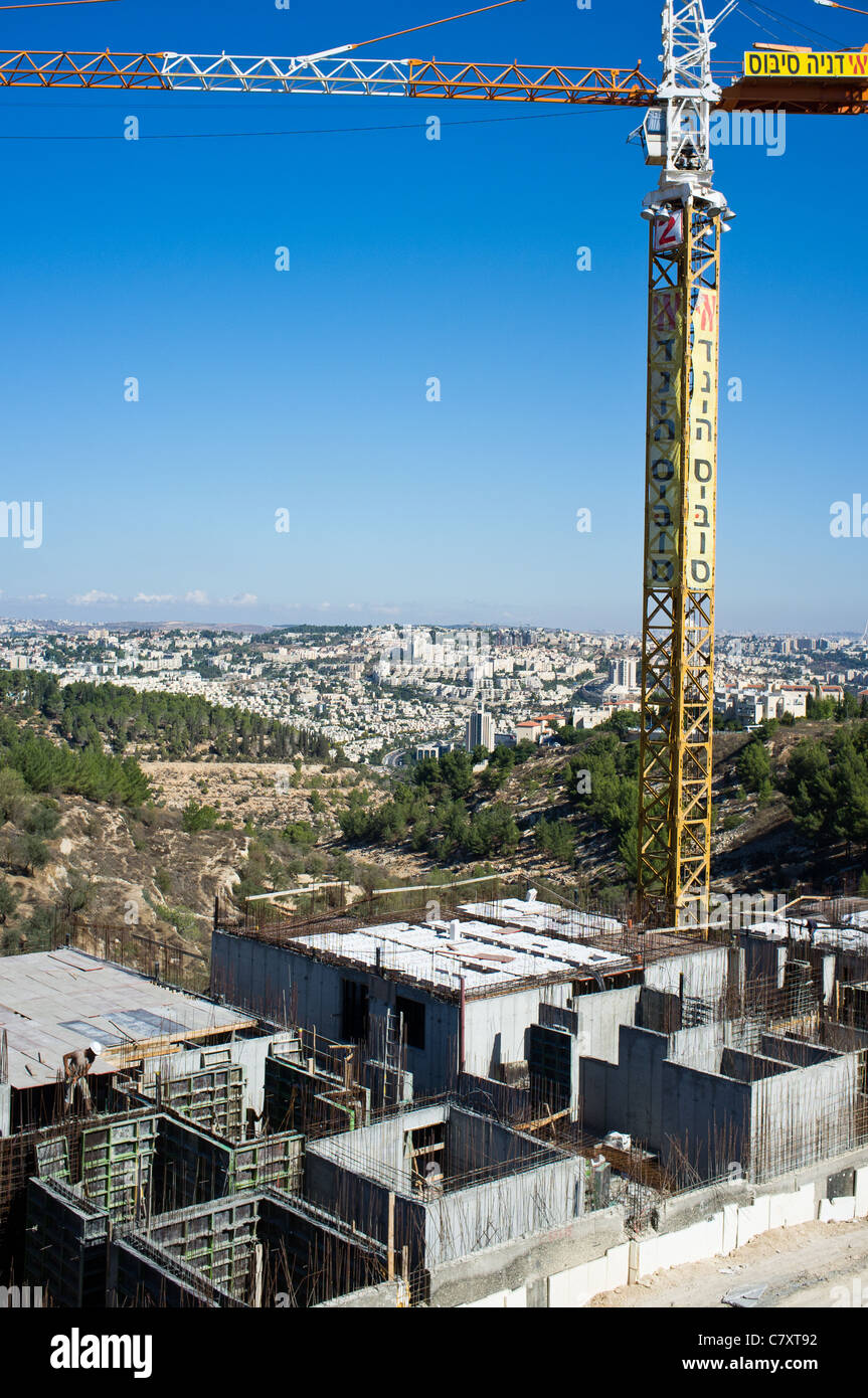 A tall crane looms over a housing construction site in Giloh Stock ...