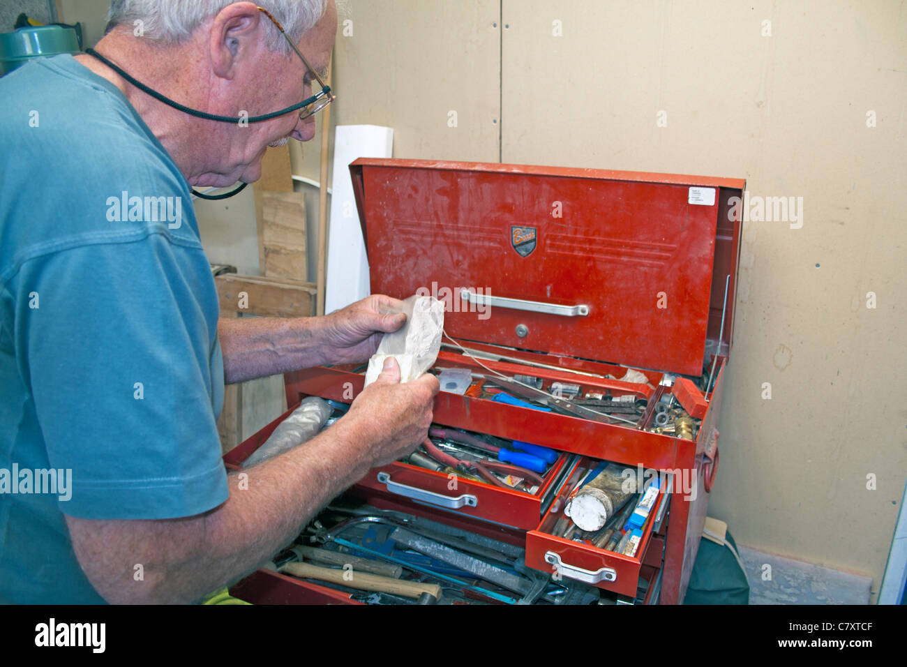 Engineer looking for tools in a red tool box Stock Photo - Alamy