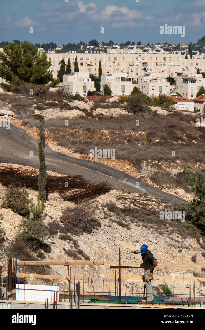 Construction workers build housing in Giloh in spite of Western ...