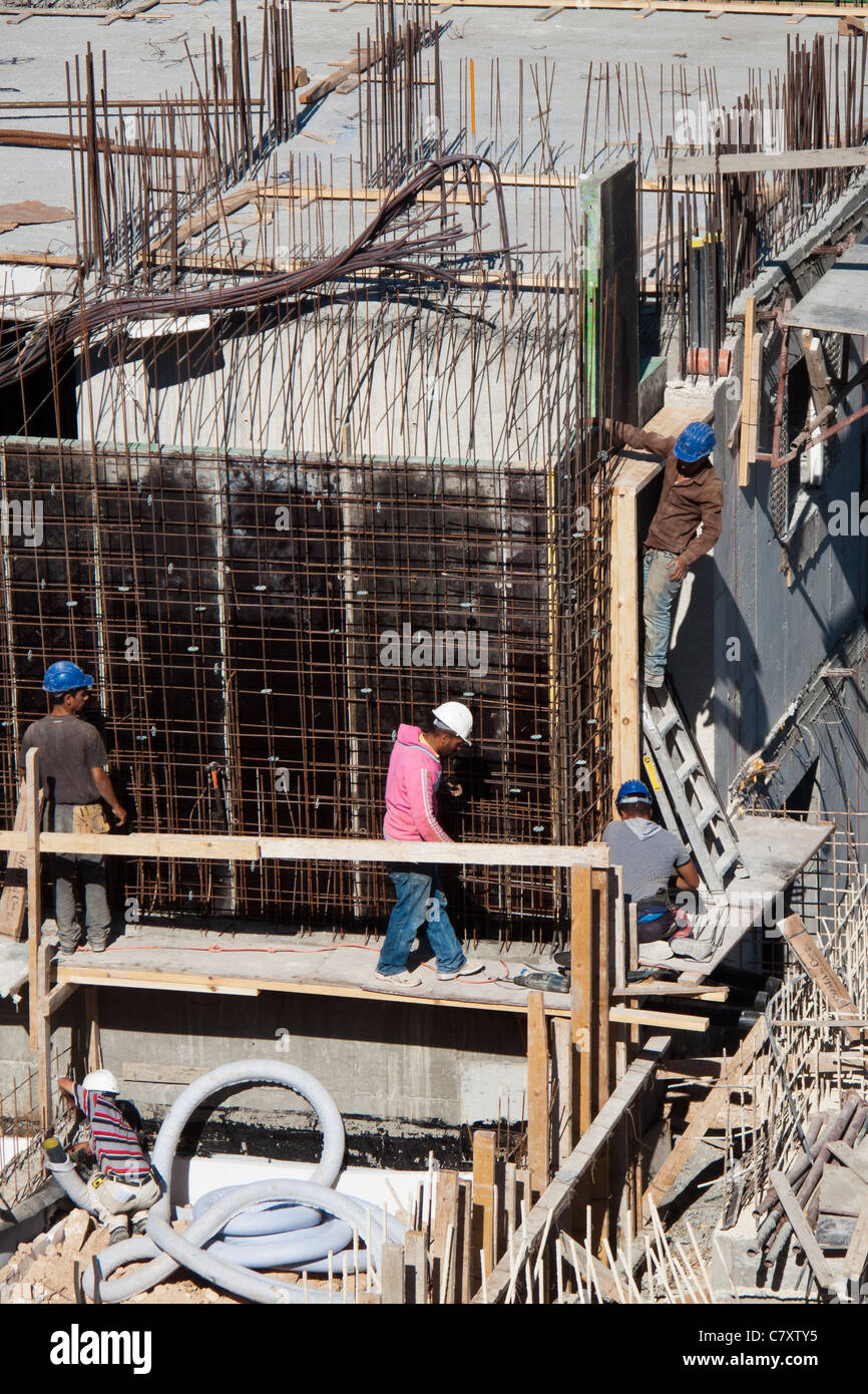 Construction workers build housing in Giloh in spite of Western ...