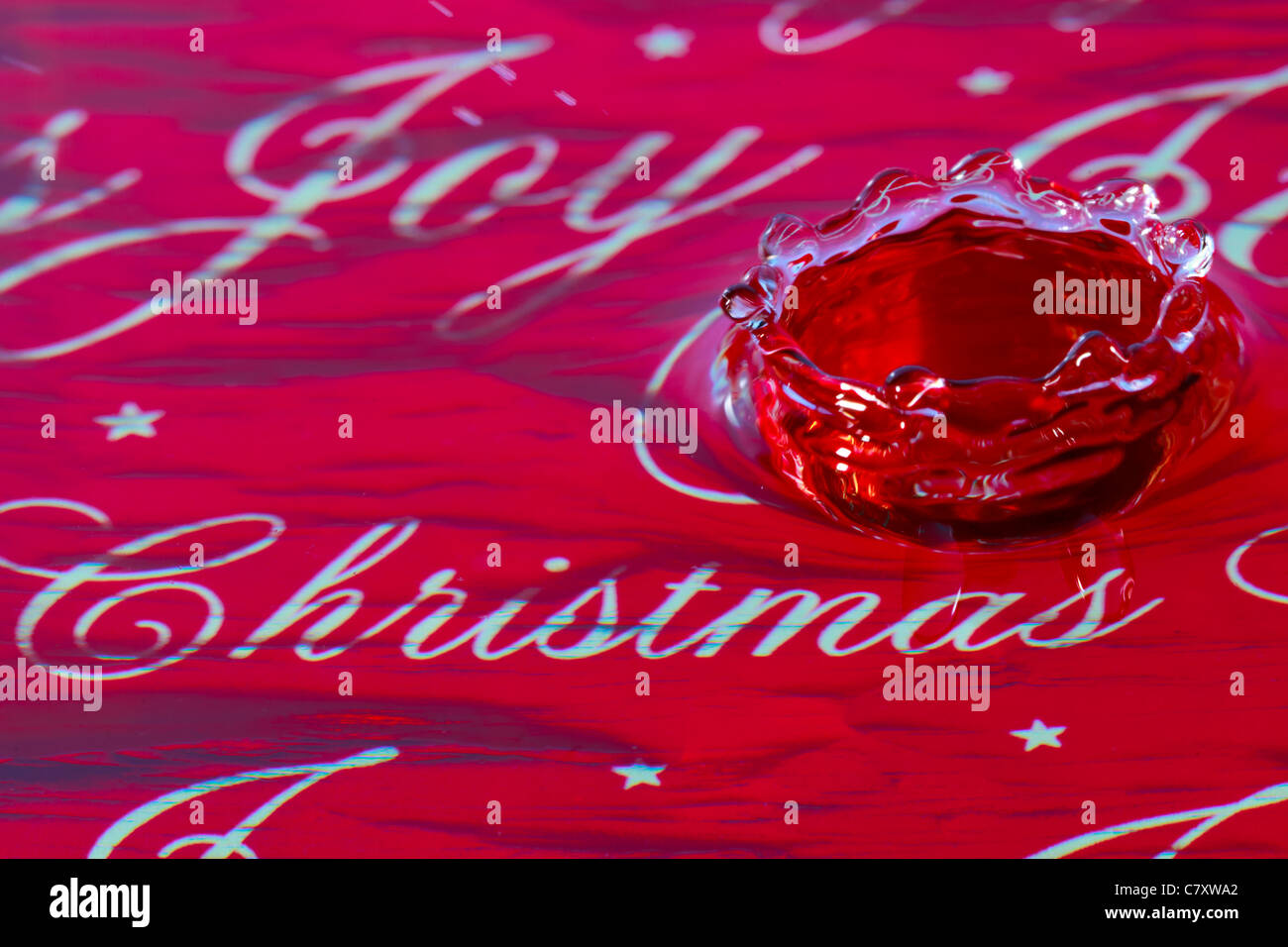 Splash in water with a red background of Christmas Joy showing through ...