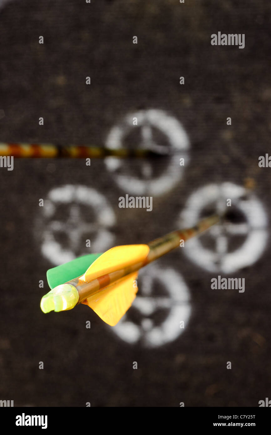 Two arrows in target's bulls-eye. Depth of field view Stock Photo - Alamy