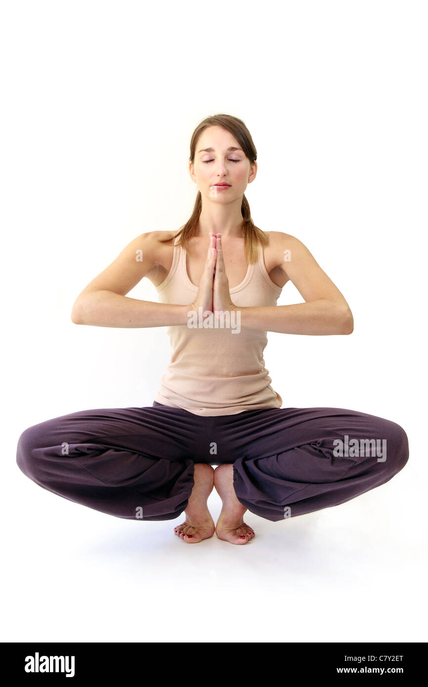 Young woman performing the frog posture in yoga Stock Photo - Alamy