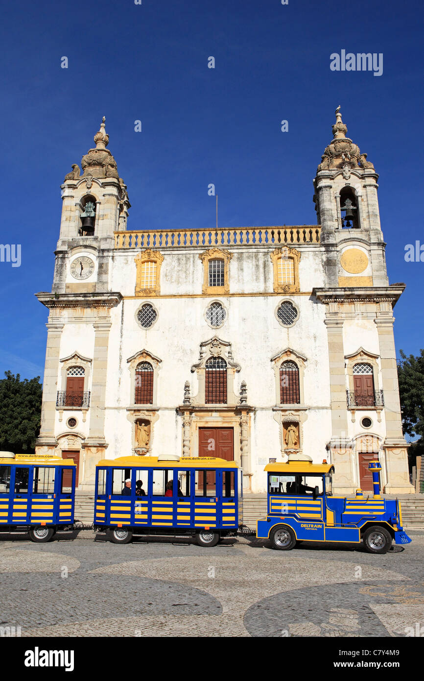 A sightseeing train runs past the Our Lady of Carmo church in Faro ...