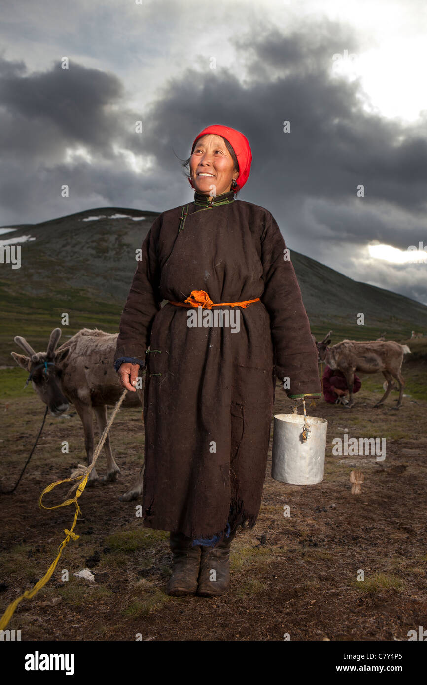 Tsaatan woman take pose after milking reindeer at evening, in Tsagaan ...