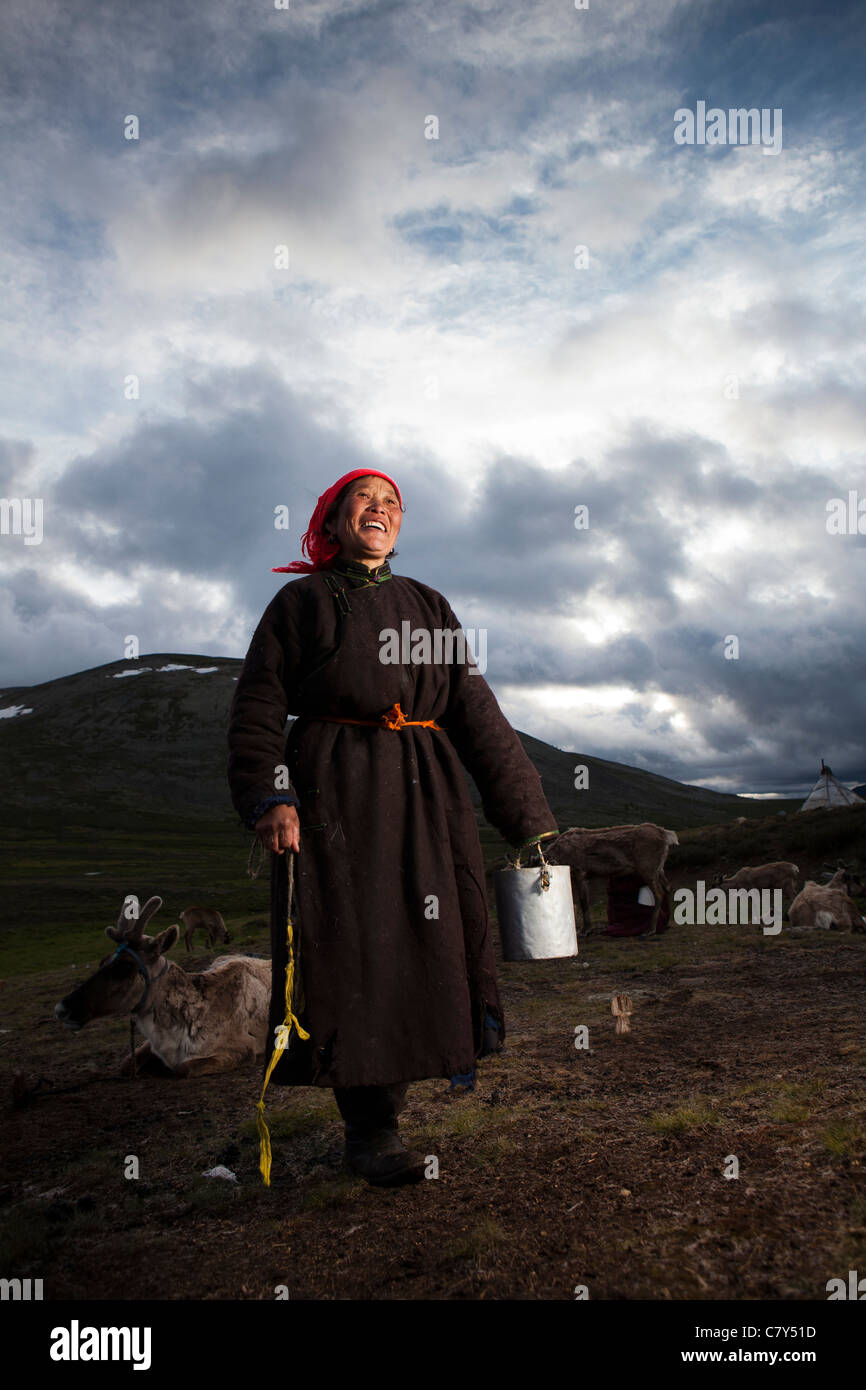 Tsaatan woman take pose after milking reindeer at evening, in Tsagaan ...