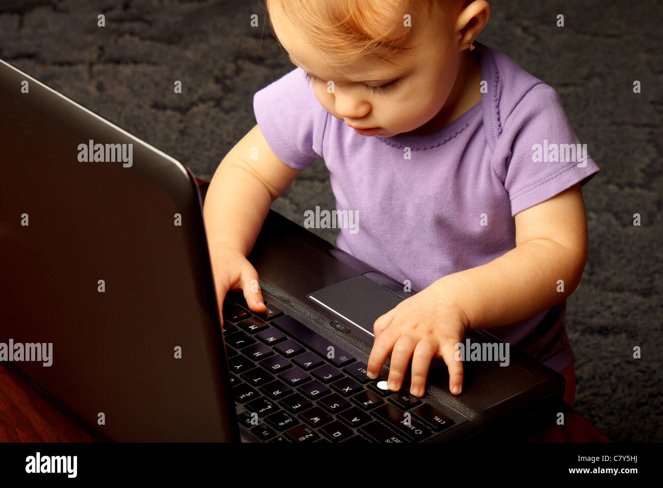 Adorable baby typing on laptop in the dark Stock Photo - Alamy