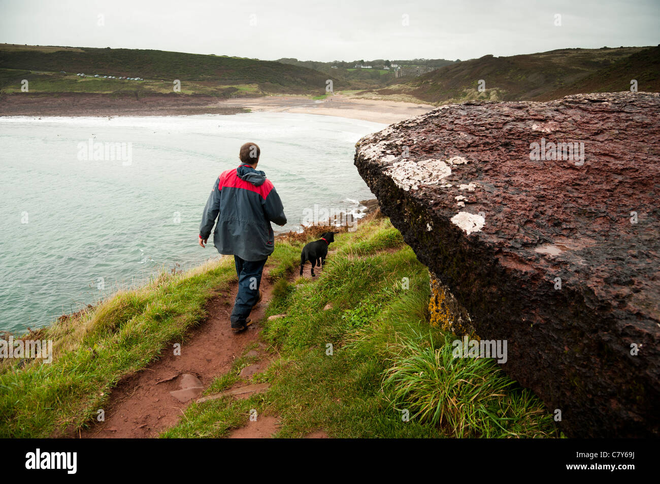 a man walking with his dog along the Pembrokeshire national park ...