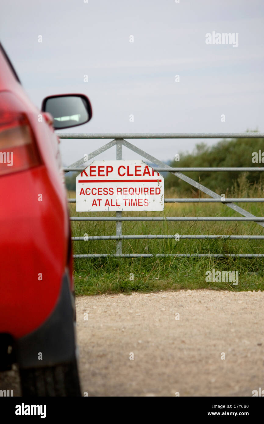 Keep clear sign with red car in foreground, UK Stock Photo - Alamy
