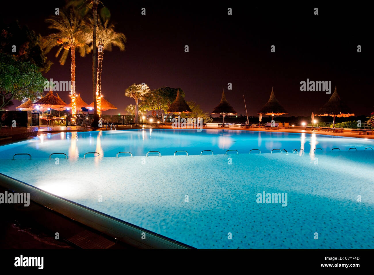 Large swimming pool in a luxury tropical hotel lit up at night Stock ...
