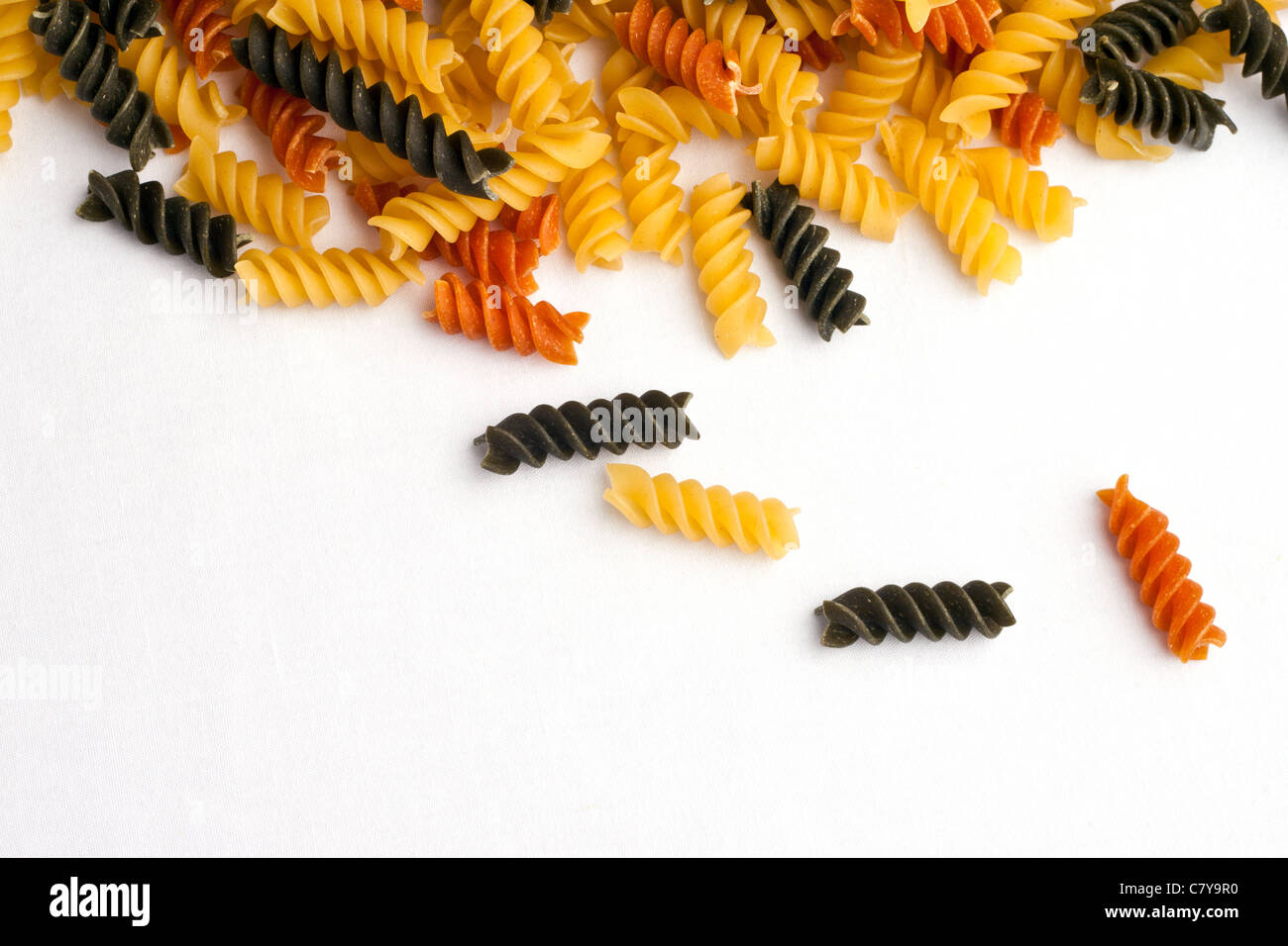 Multicolored noodles spilled across white surface Stock Photo - Alamy