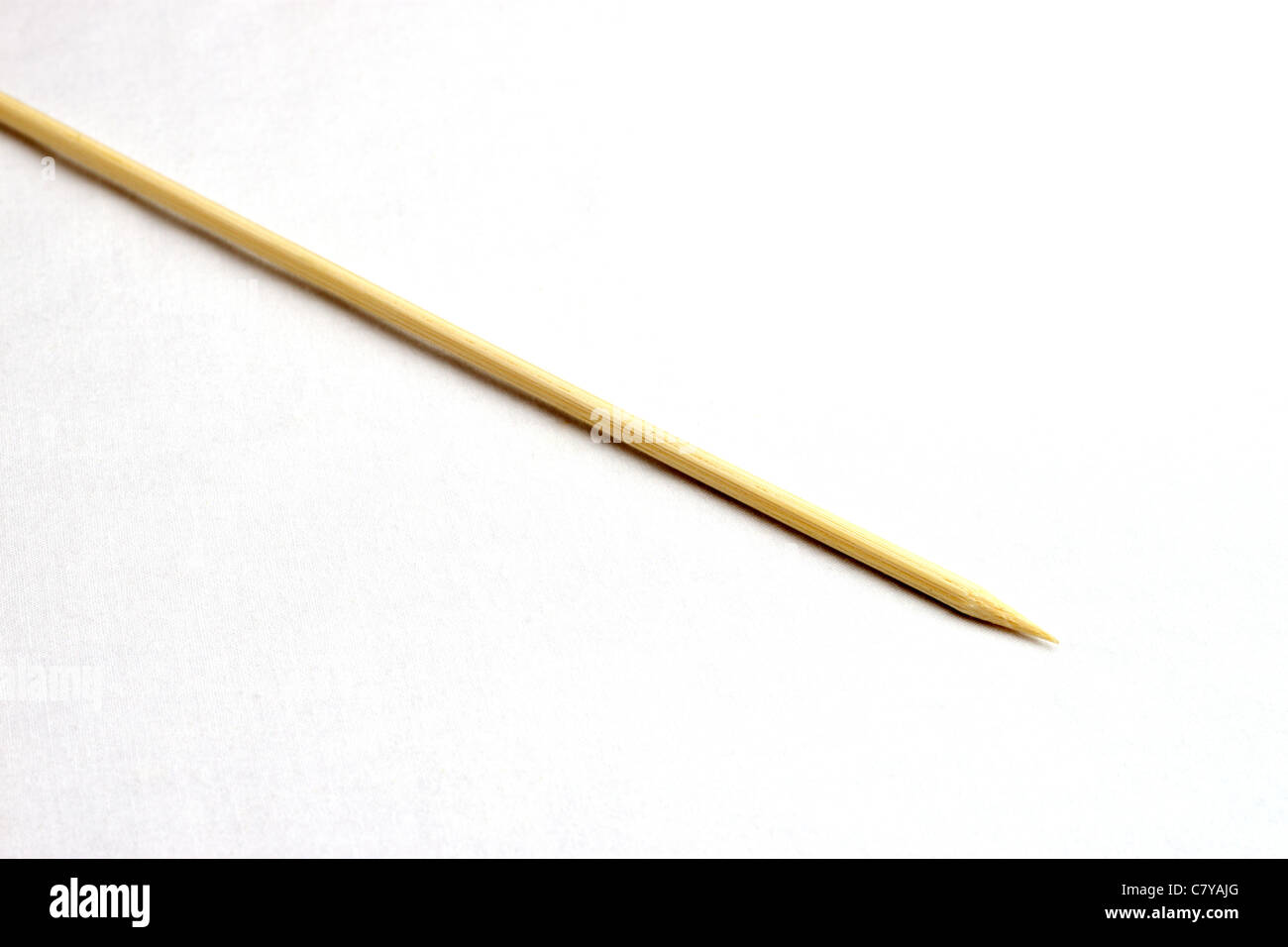 Single wooden bamboo skewer laying on white background Stock Photo - Alamy