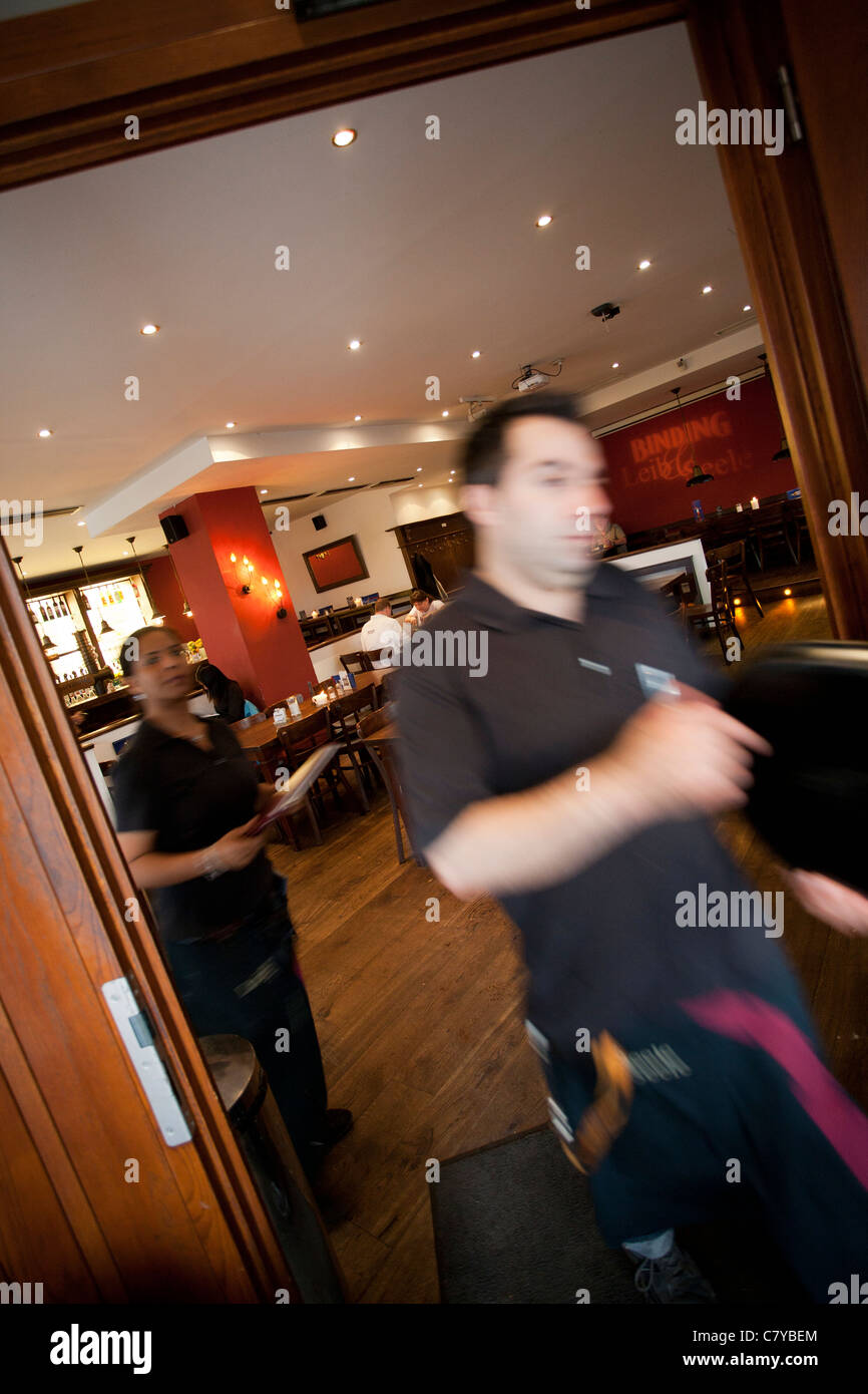 Waiter and waitress walking out of a bar in Frankfurt am Main Stock ...