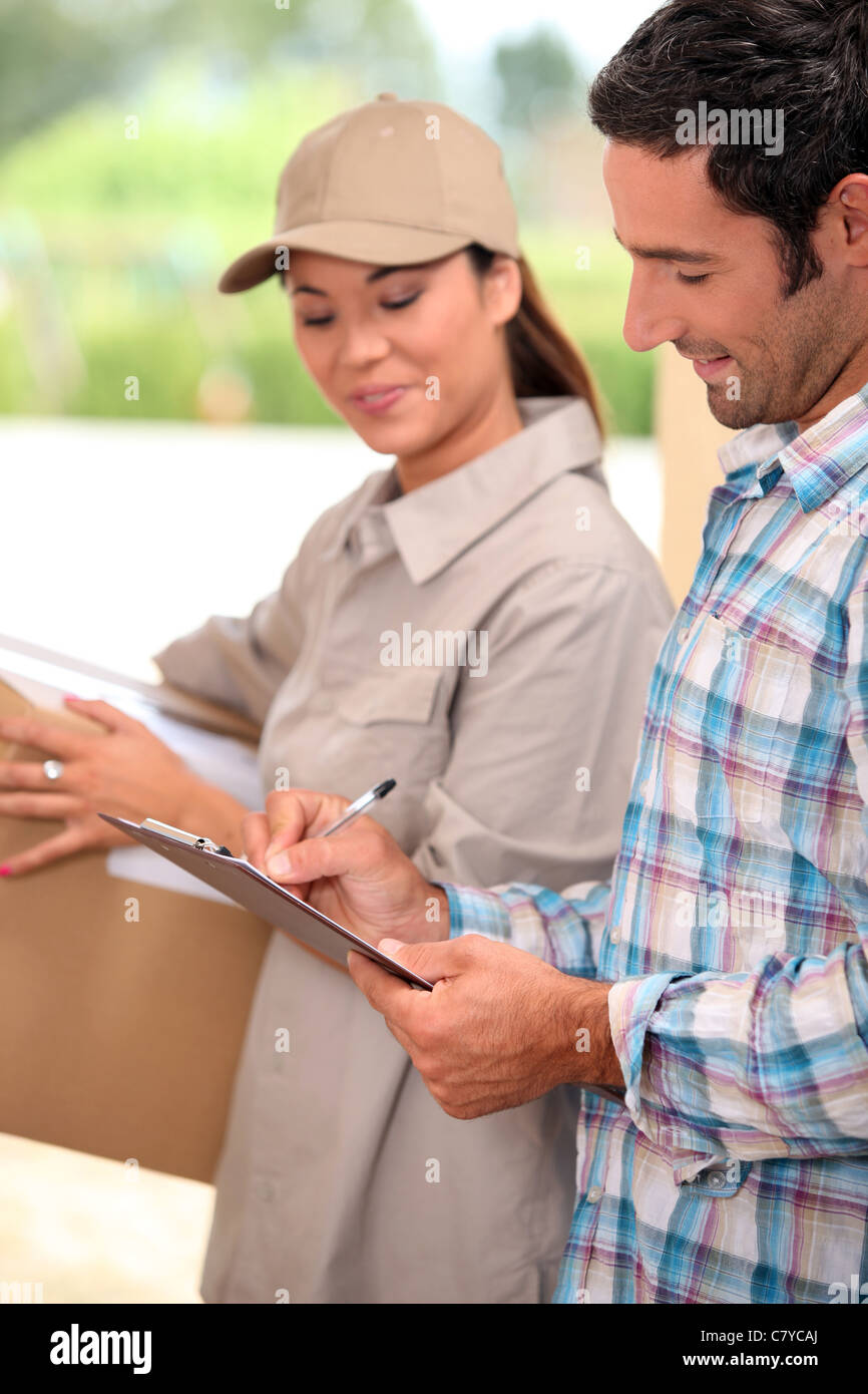 Man signing for the delivery of a parcel Stock Photo - Alamy
