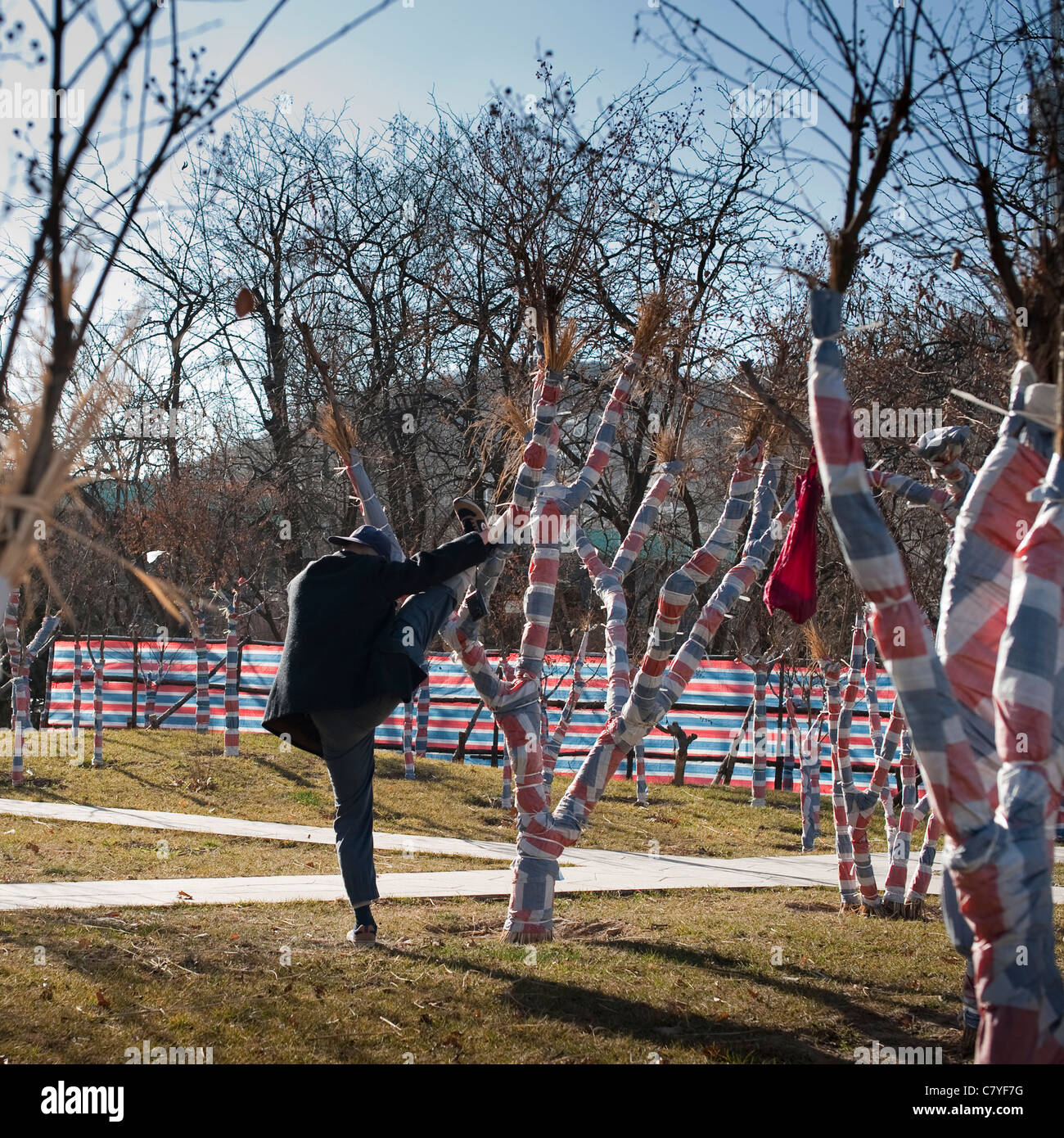 Chinese man doing strenuous leg stretch exercises in the park Stock ...