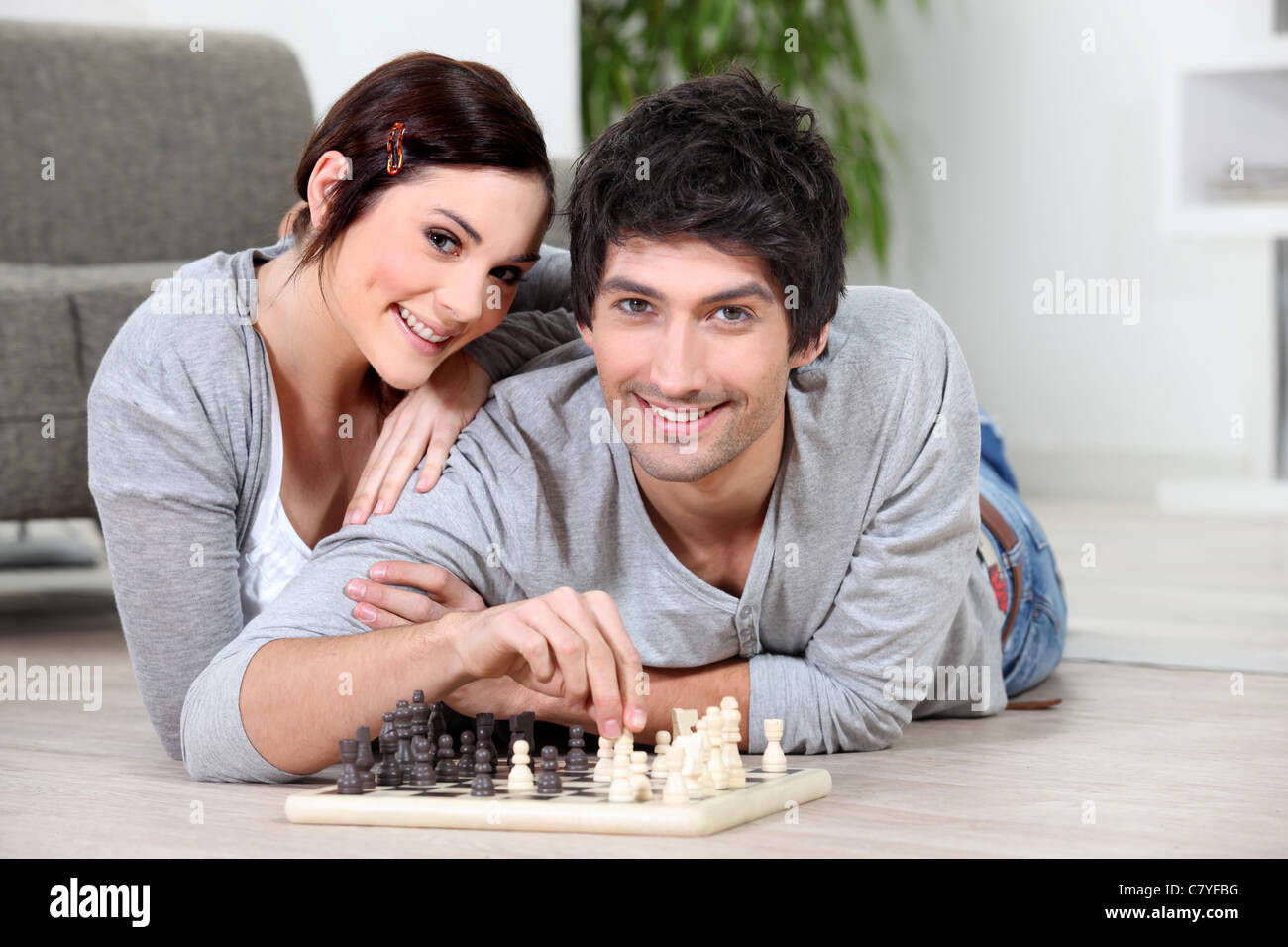 Couple laying on floor playing chess Stock Photo - Alamy