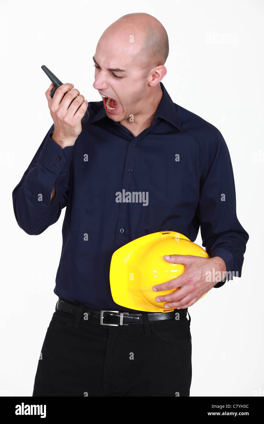 Engineer screaming into a walkie-talkie Stock Photo - Alamy