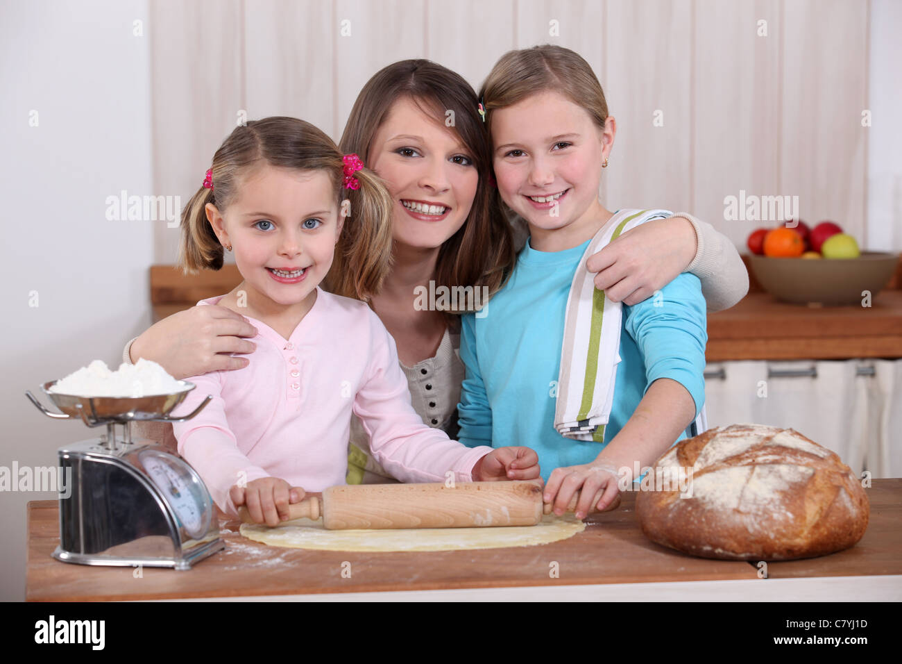 Mother and daughters making bread Stock Photo - Alamy