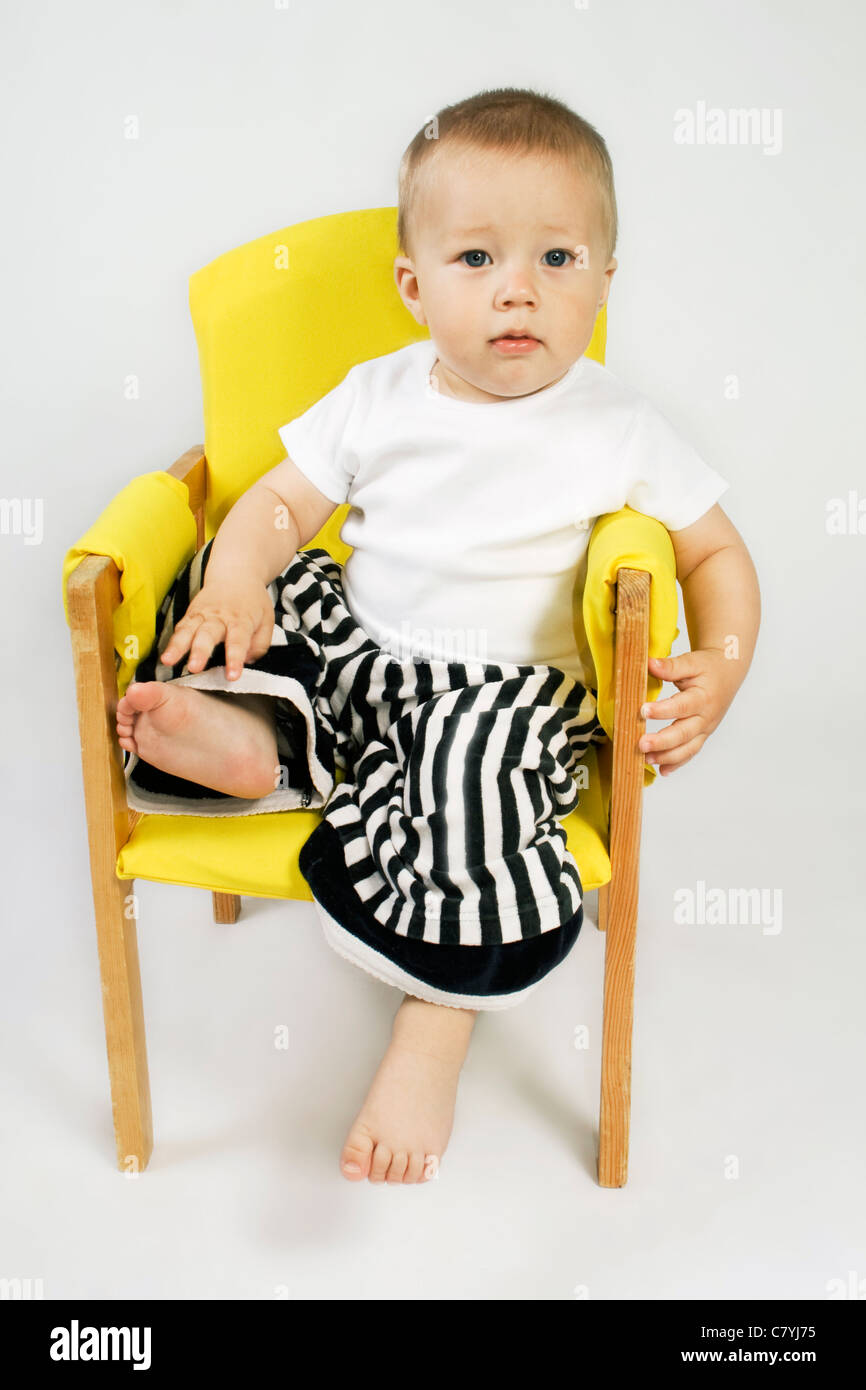 Little boy sitting on chair in striped pants Stock Photo - Alamy