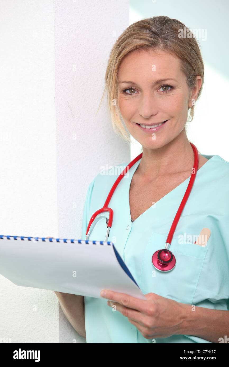 Female nurse holding paperwork Stock Photo - Alamy