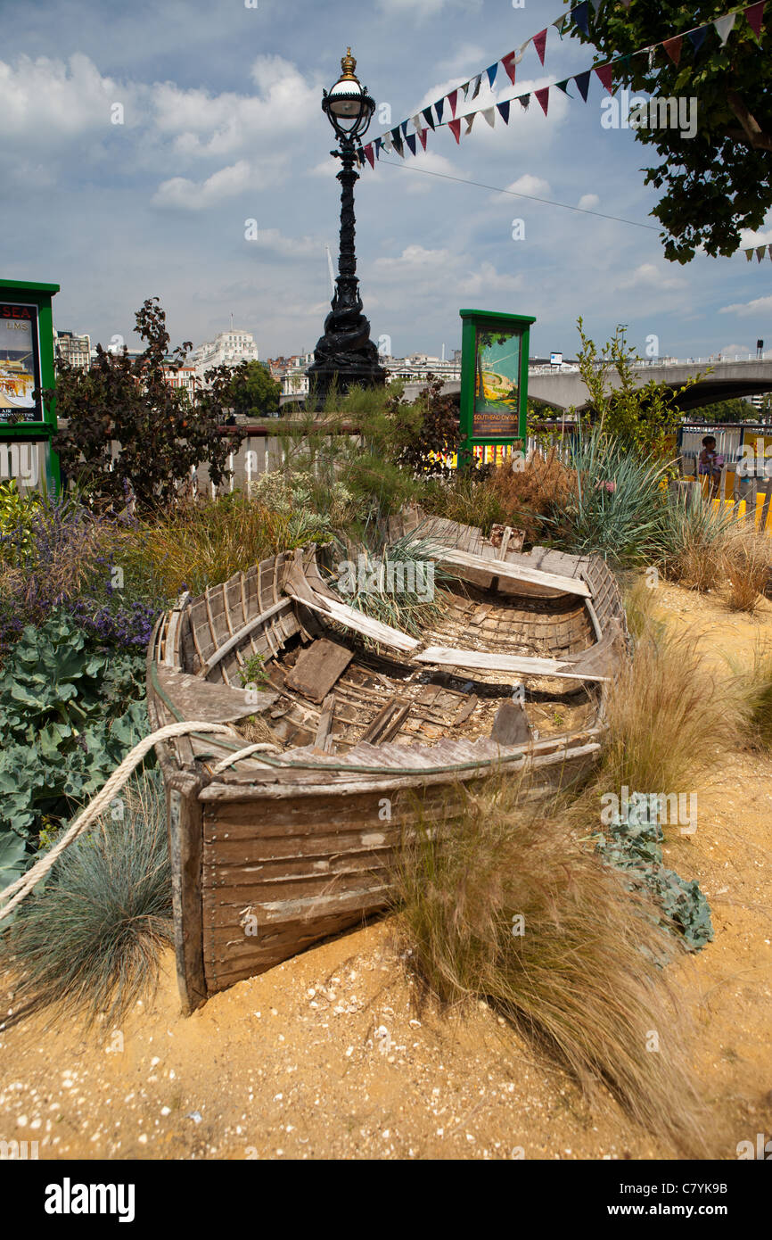 A shipwrecked rowing boat is part of a summer display on the South Bank ...