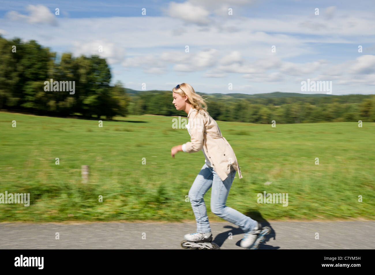 Inline skating young woman speed workout sunny asphalt road Stock Photo ...