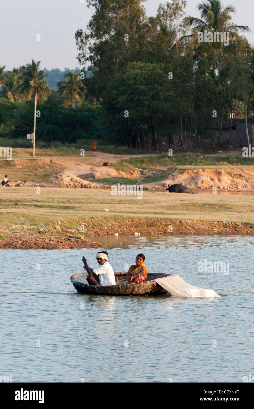 Indian man and woman net fishing in a coracle boat. Andhra Pradesh ...
