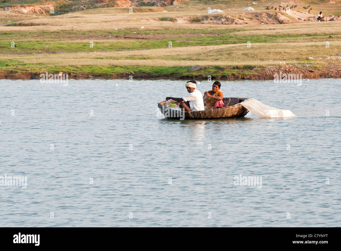 Indian man and woman net fishing in a coracle boat. Andhra Pradesh ...