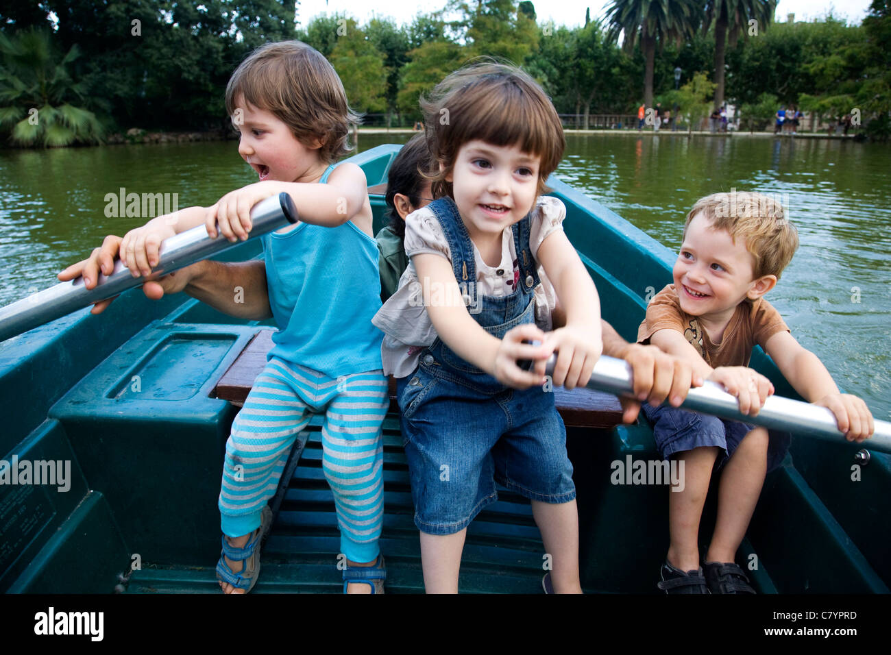 Three young children rowing on a lake Stock Photo - Alamy