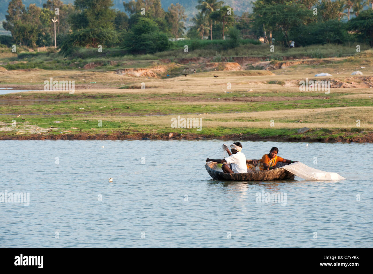 Indian man and woman net fishing in a coracle boat Stock Photo - Alamy