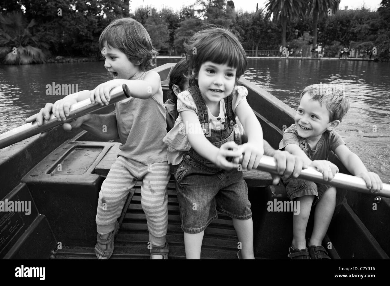 Three young children rowing on a lake Stock Photo - Alamy