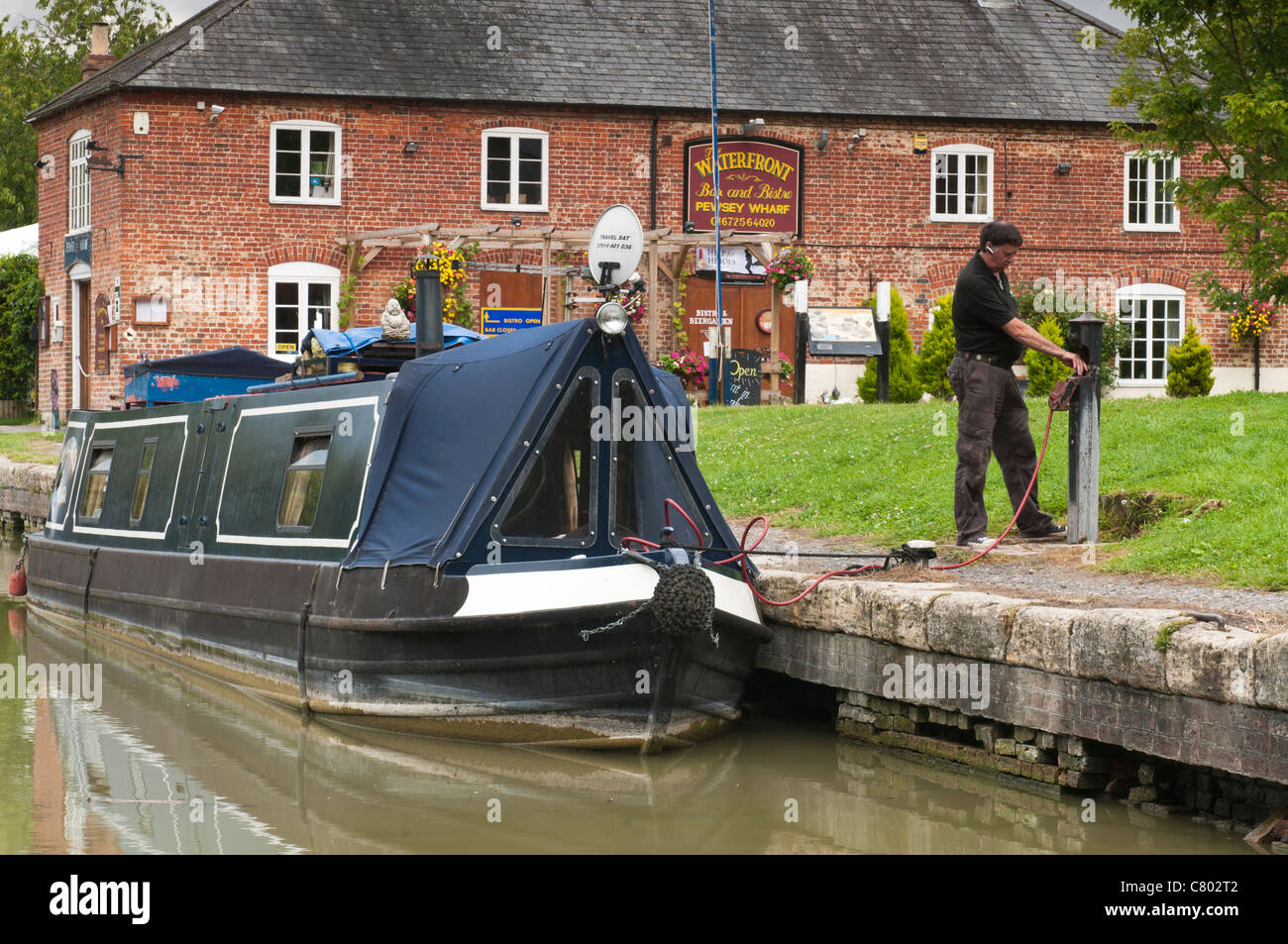 a man maintaining his canal boat at Pewsey Wharf, Kennet and Avon Canal ...