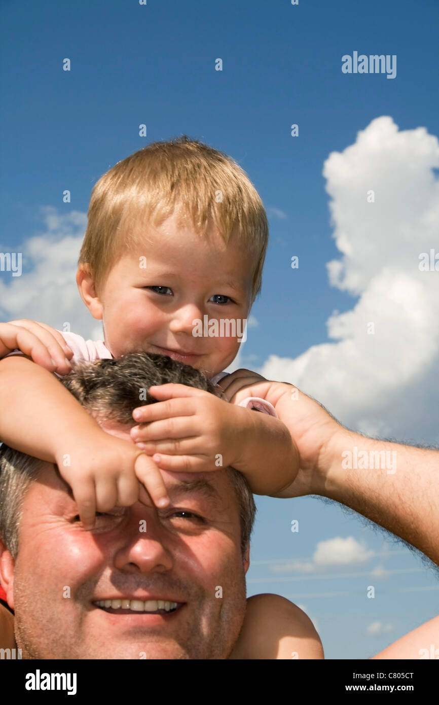 Happy father and his son straddle on shoulders Stock Photo - Alamy