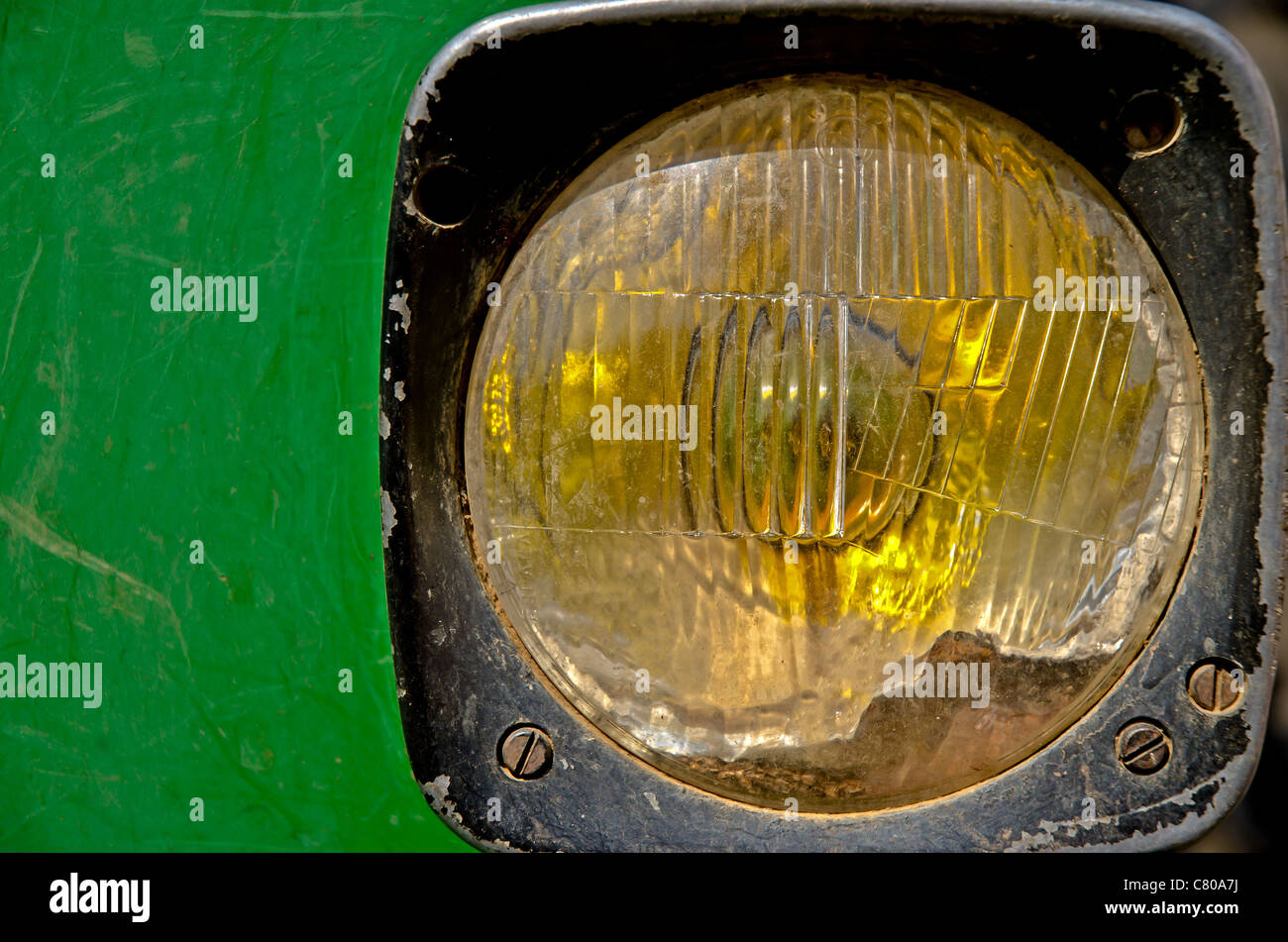 Vintage tractor front yellow light on green painted metal background ...