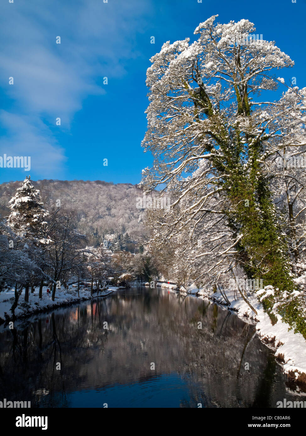 Snow scene at Matlock Bath in Derbyshire UK with trees reflected in the ...