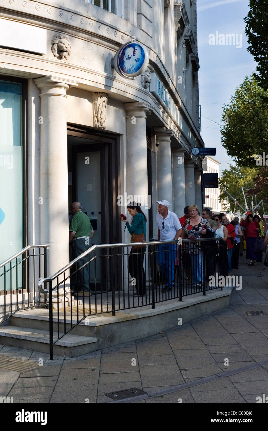 line of customers in a queue waiting for a bank to open Stock Photo - Alamy