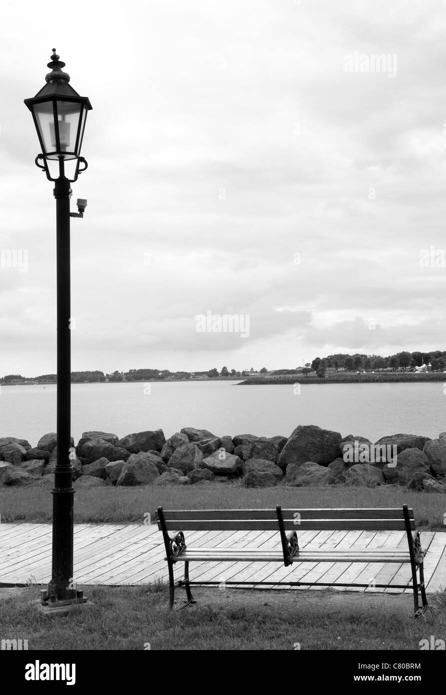 Black and white simple image of an iron lamp post and park bench ...