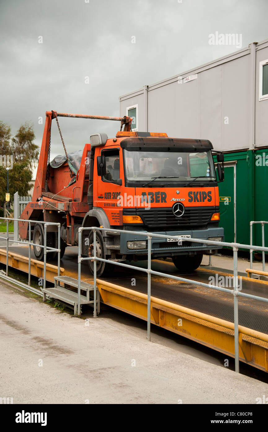A skip dumpster truck on a weigh-bridge at a waste transfer recycling ...