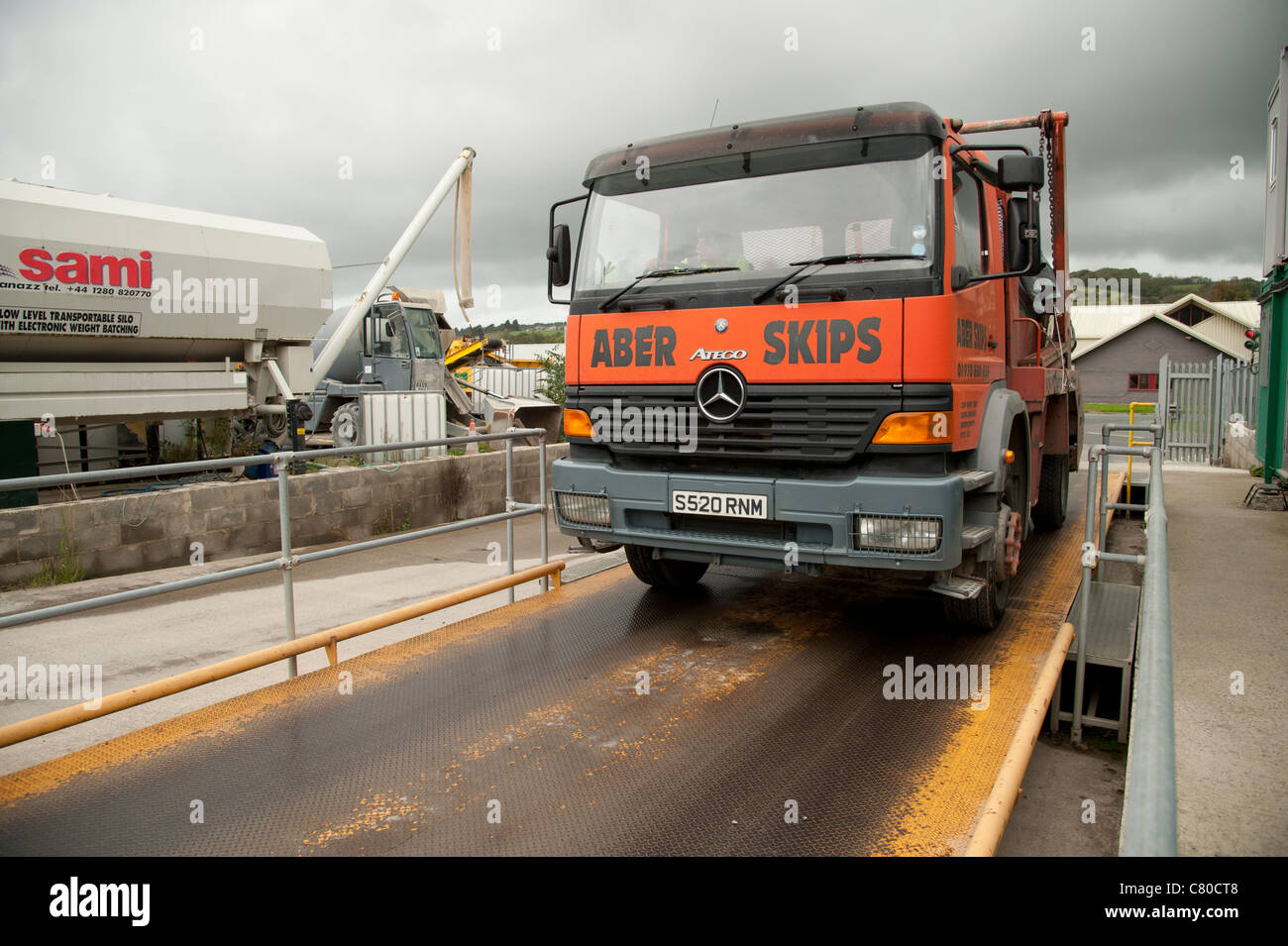A skip dumpster truck on a weigh-bridge at a waste transfer recycling ...