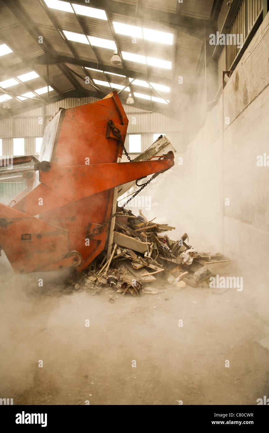Unloading a skip full of building site rubble at a recycling yard UK ...