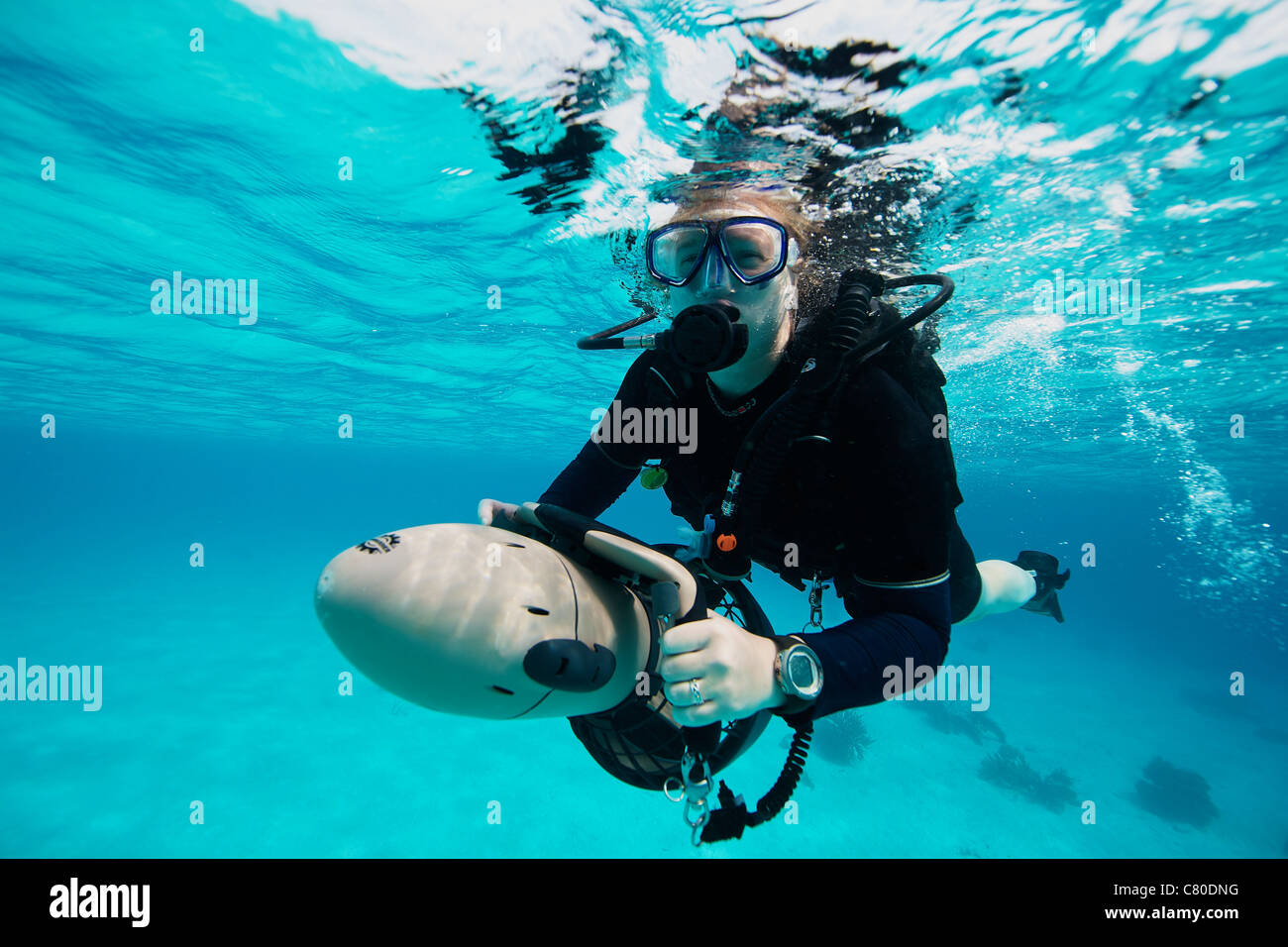 Scuba diver navigates the waters using a diver propulsion vehicle off ...