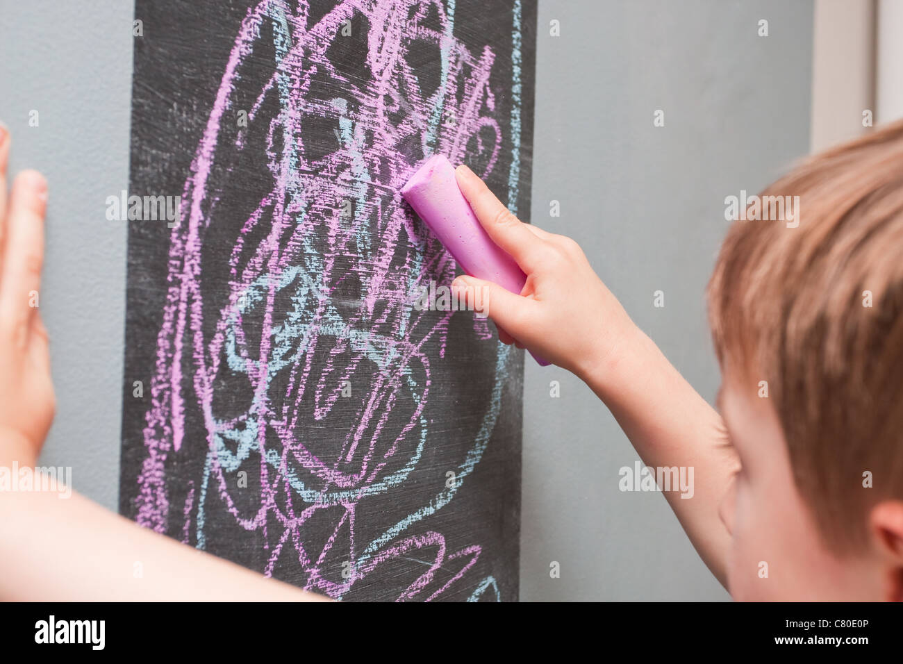 Young child drawing on a chalk board Stock Photo - Alamy