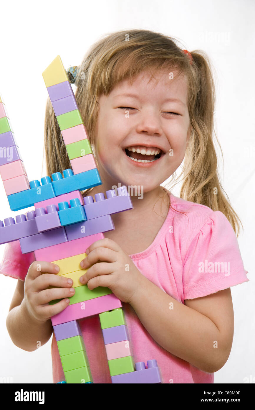 Cheerful little girl playing with toy - plastic blocks Stock Photo - Alamy