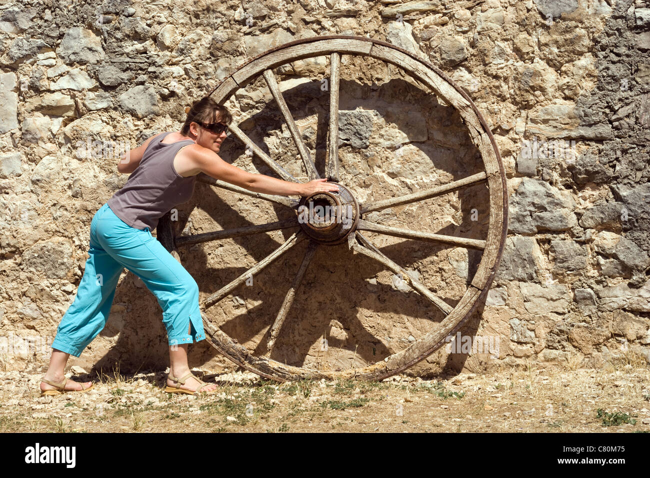 Woman pushed wheel - brickwall background Stock Photo - Alamy